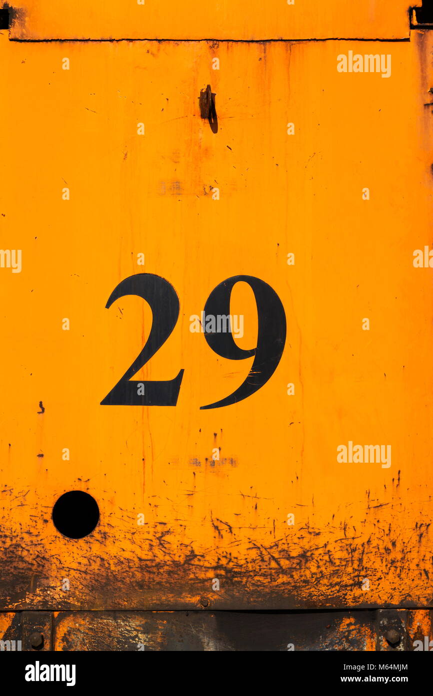 Number 29 on rusty orange metal sheet plate with hole Stock Photo - Alamy