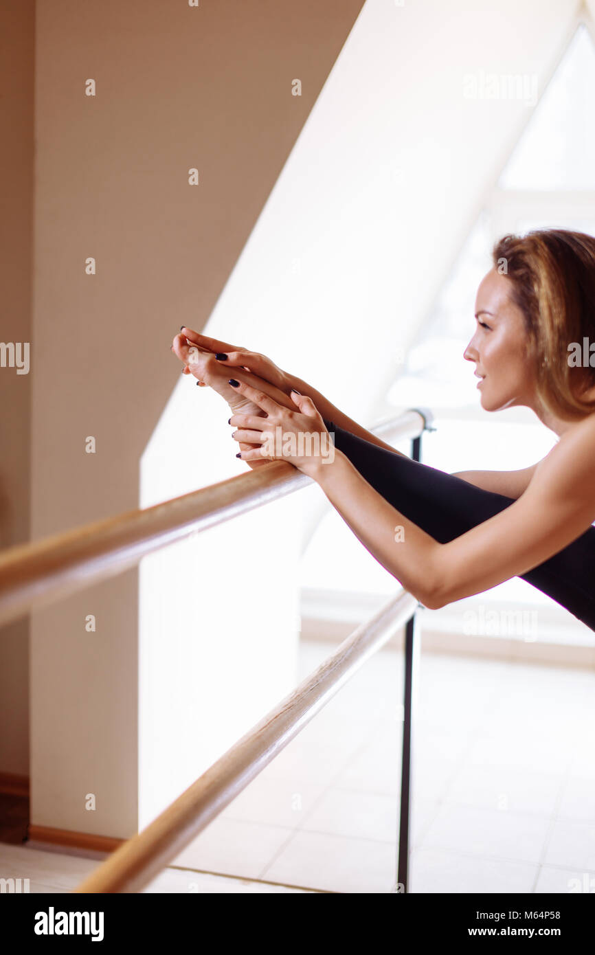 Girl smiling and looking in mirror while stretching body in fitness ...
