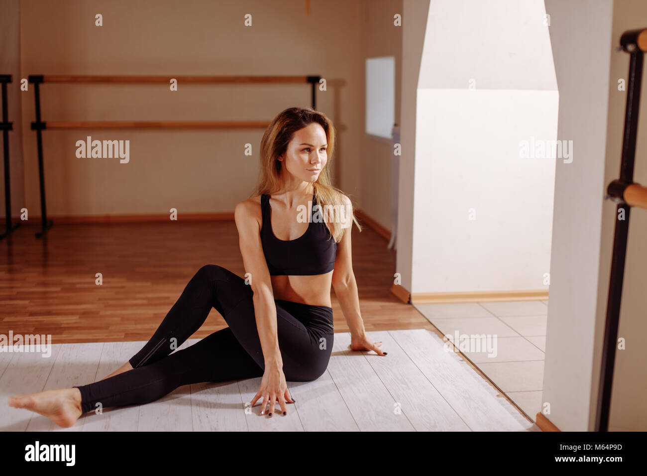Woman stretching seated spinal twist. Young slim girl makes exercise ...
