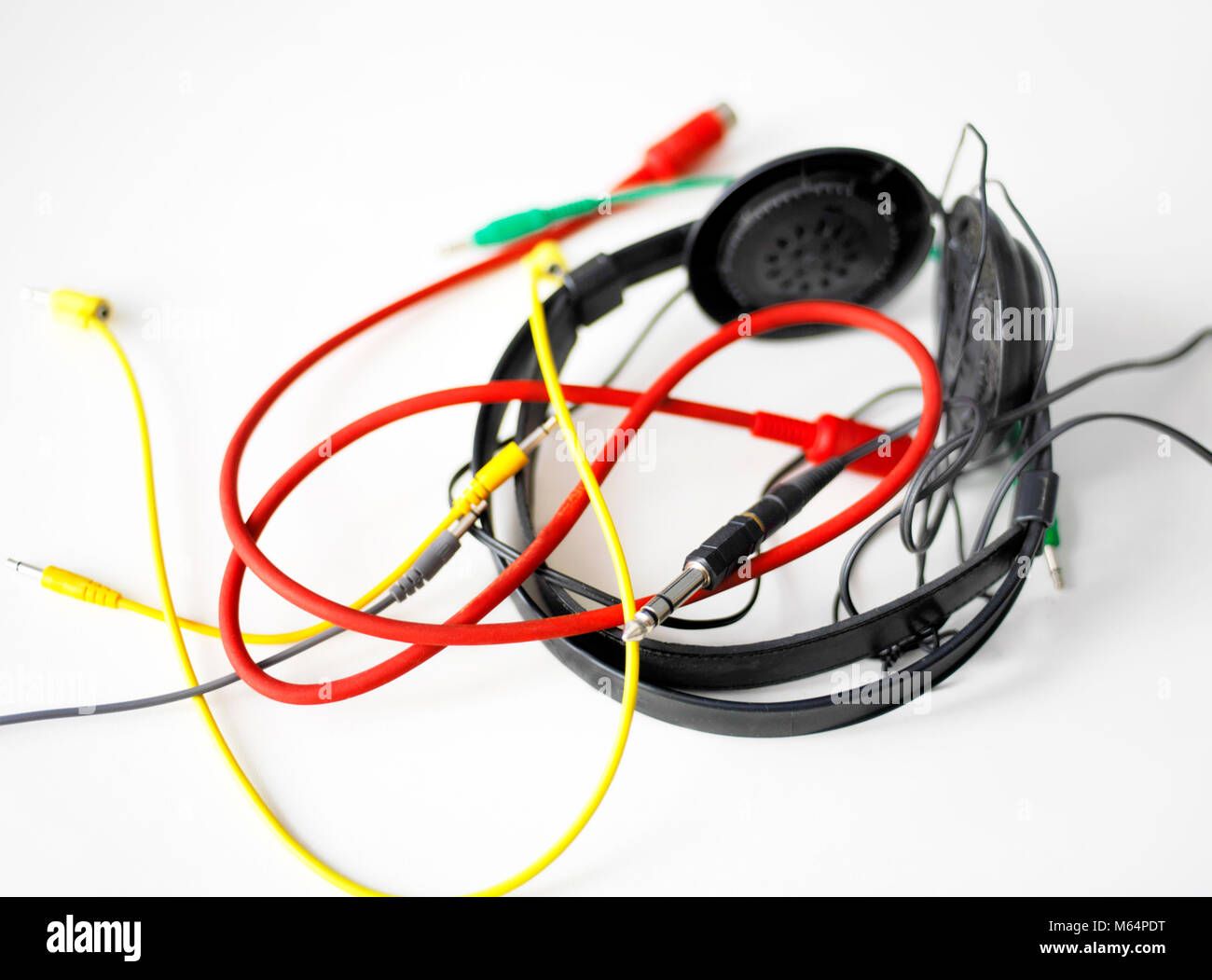 Headphones and tangled messy audio cables laid on the gray table, indoor closeup Stock Photo - Alamy