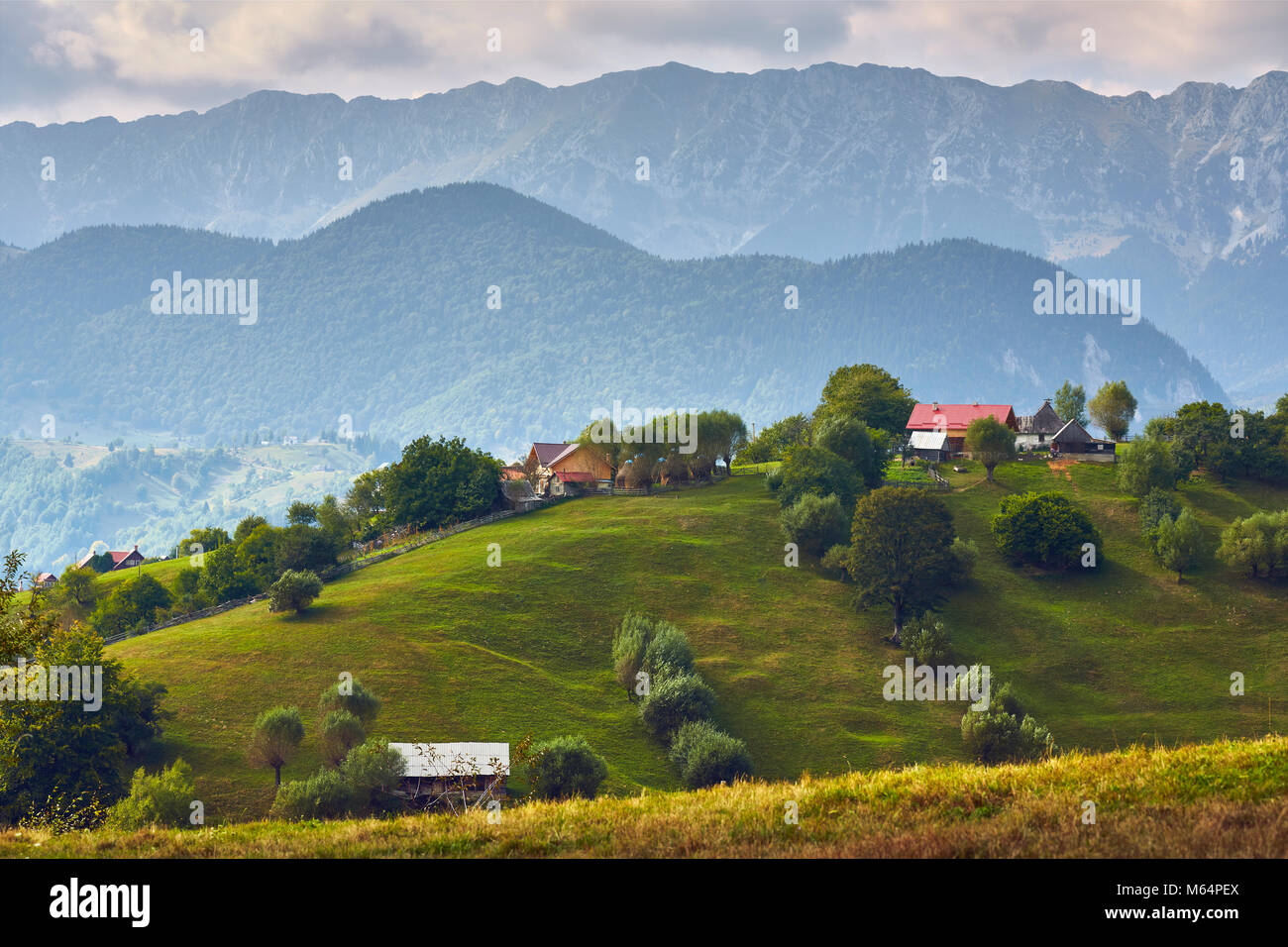 Springtime rural landscape with Romanian village on a green hill near ...