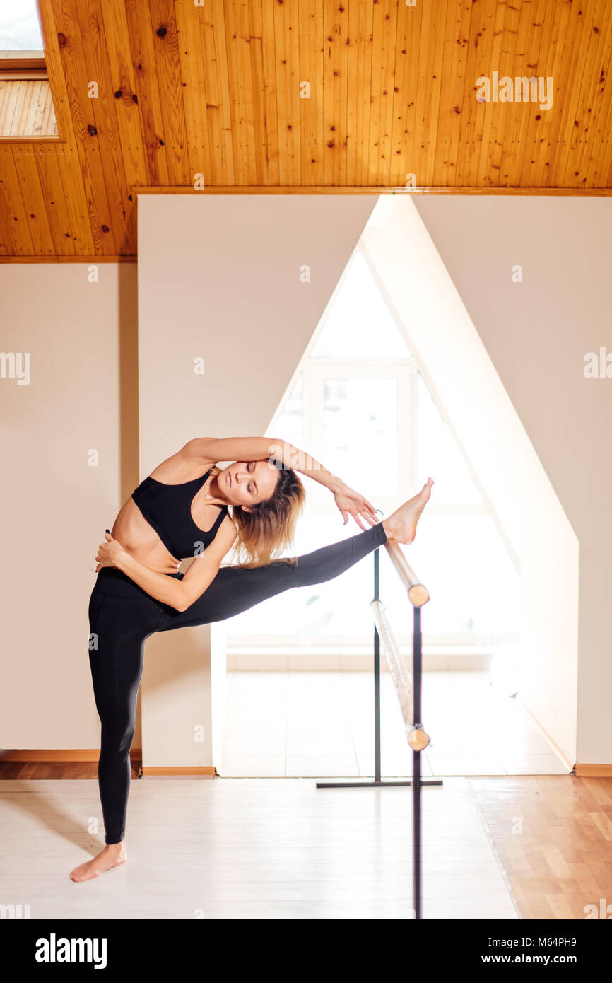 Girl smiling and looking in mirror while stretching body in fitness ...