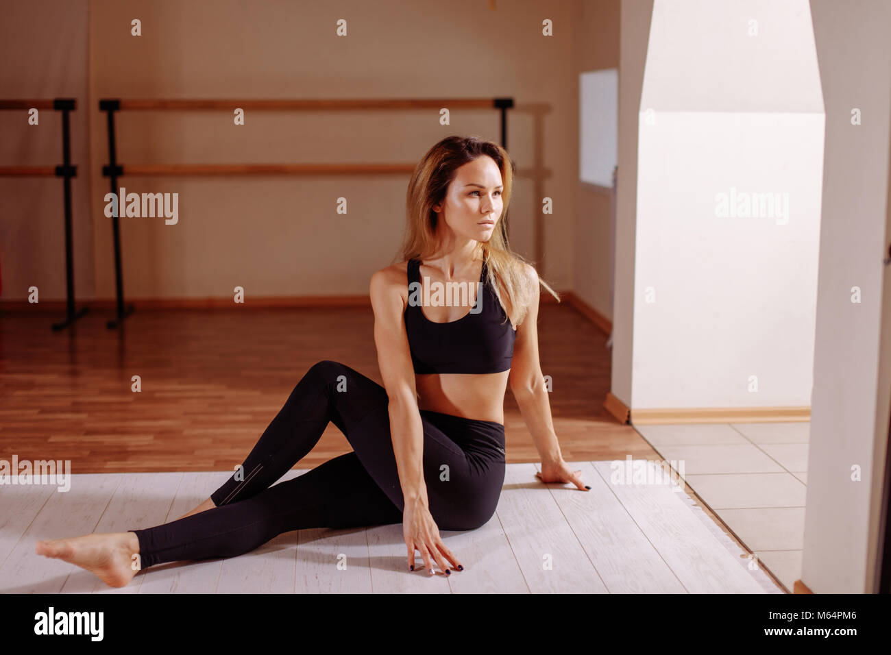 Woman stretching seated spinal twist. Young slim girl makes exercise ...