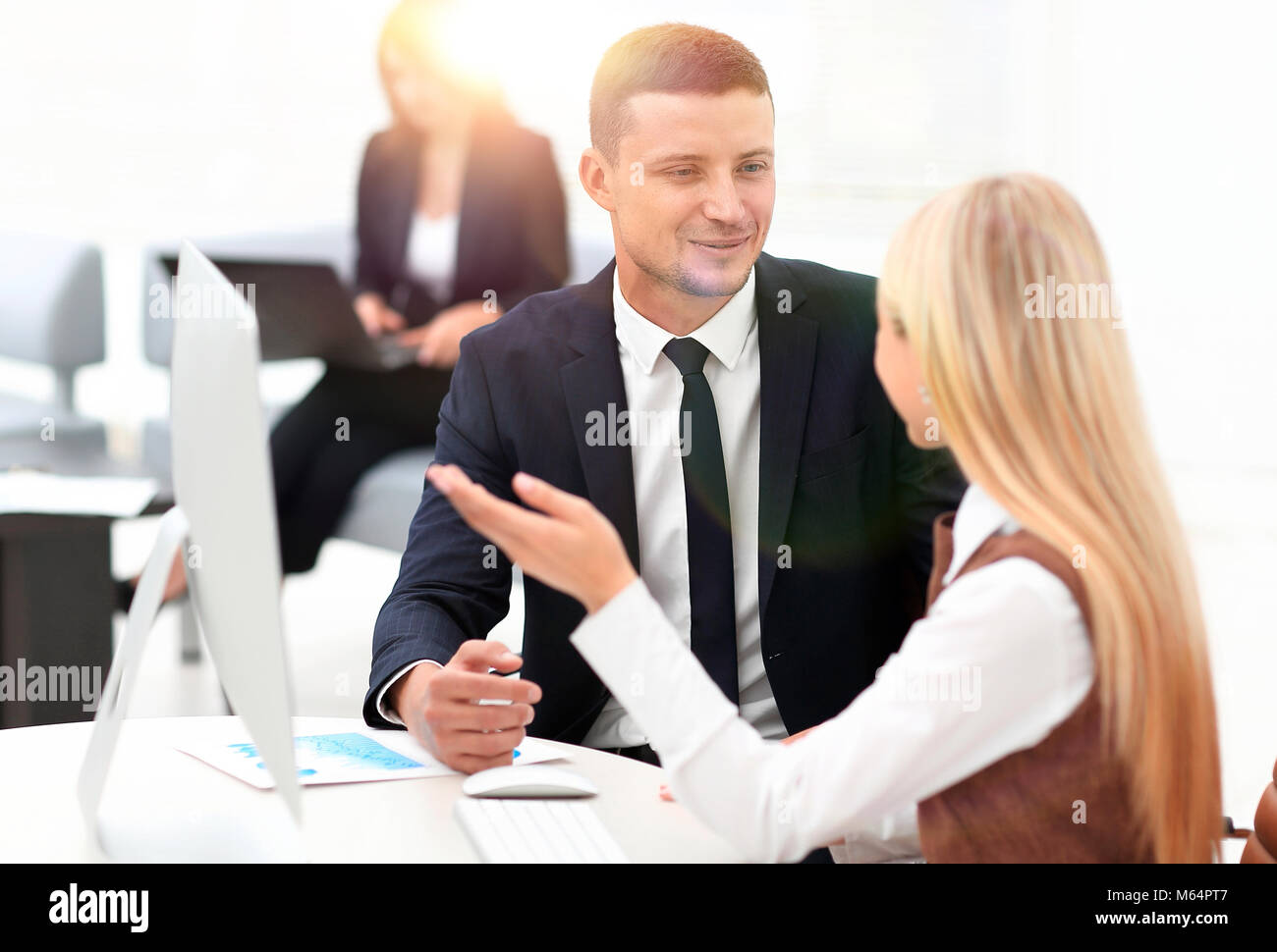 Manager talking with a colleague at the workplace Stock Photo - Alamy
