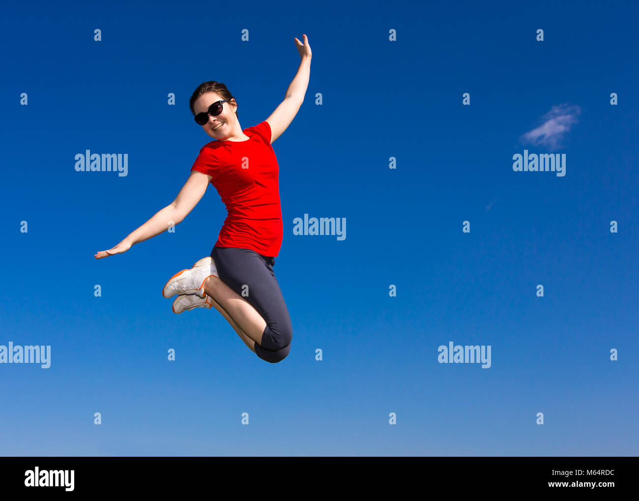 Teenage girl jumping outdoor against blue sky Stock Photo - Alamy