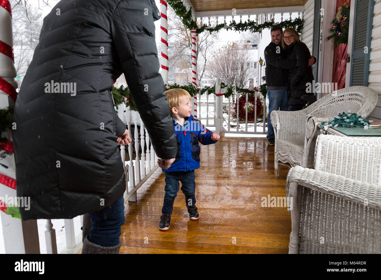 Three Adults And One Child Greet One Another On A Christmas Decorated ...