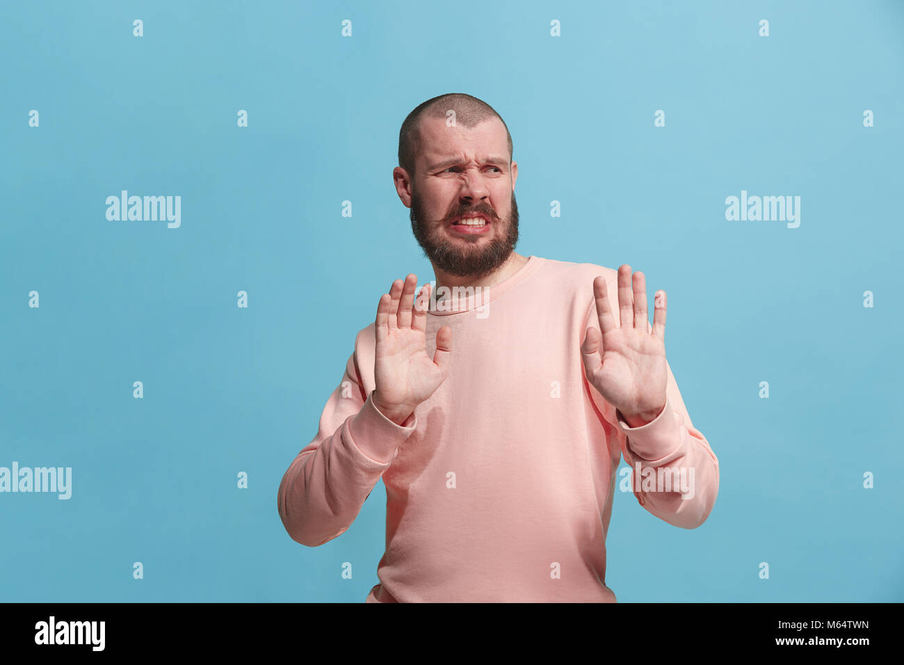 Young man with disgusted expression repulsing something, isolated on ...