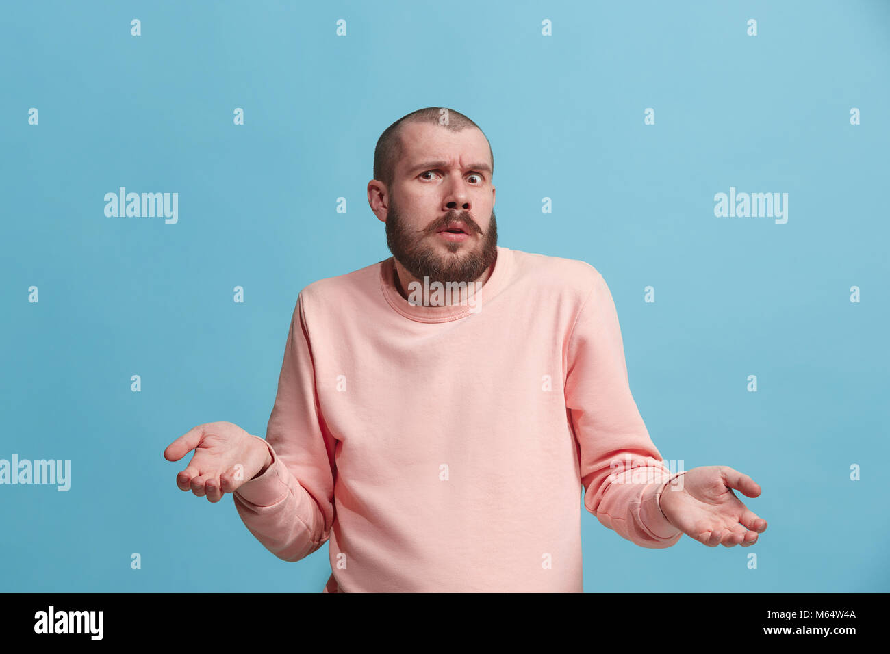Beautiful man looking suprised and bewildered isolated on blue Stock ...