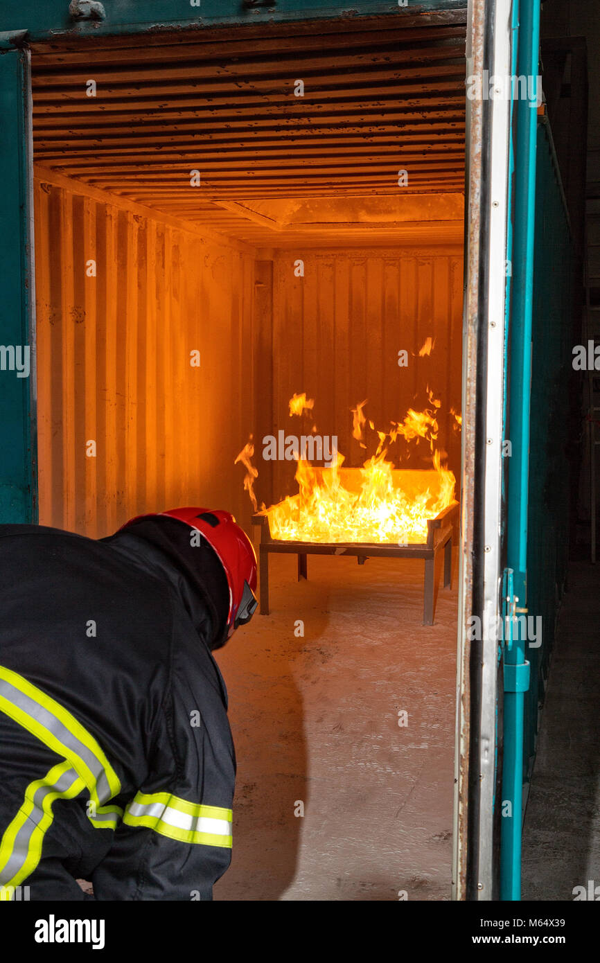 Fireman during training. Fire extinguisher. Golden yellow flames / fire ...
