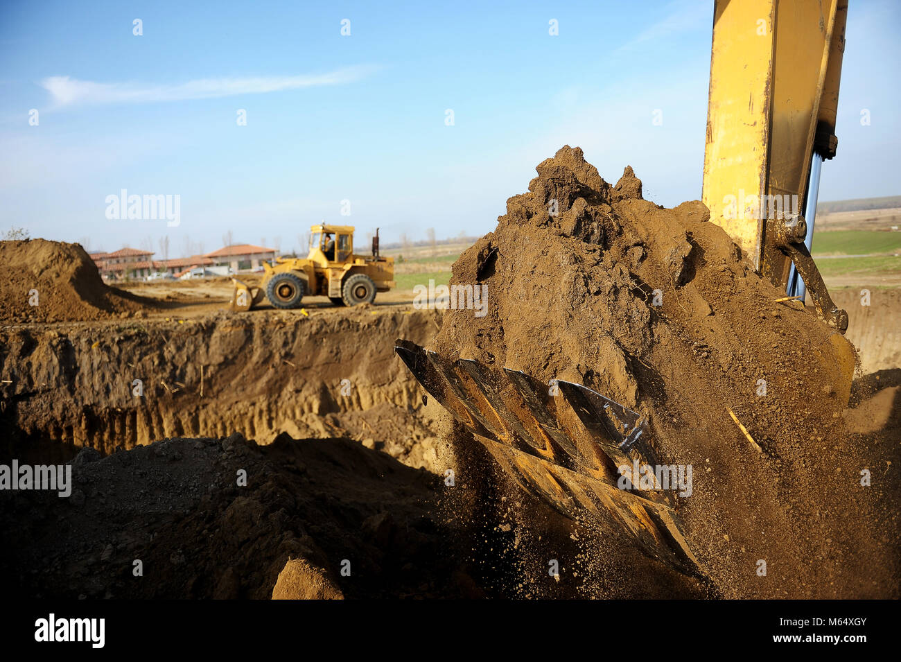 Big excavator in action on construction site Stock Photo - Alamy