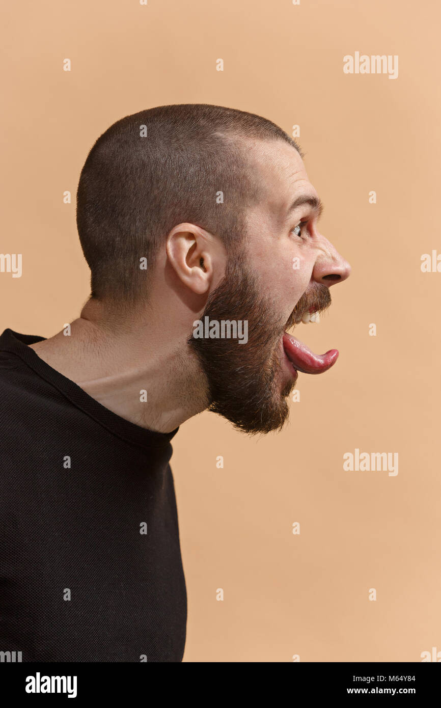 The young emotional angry, crazy man on pastel studio background Stock ...