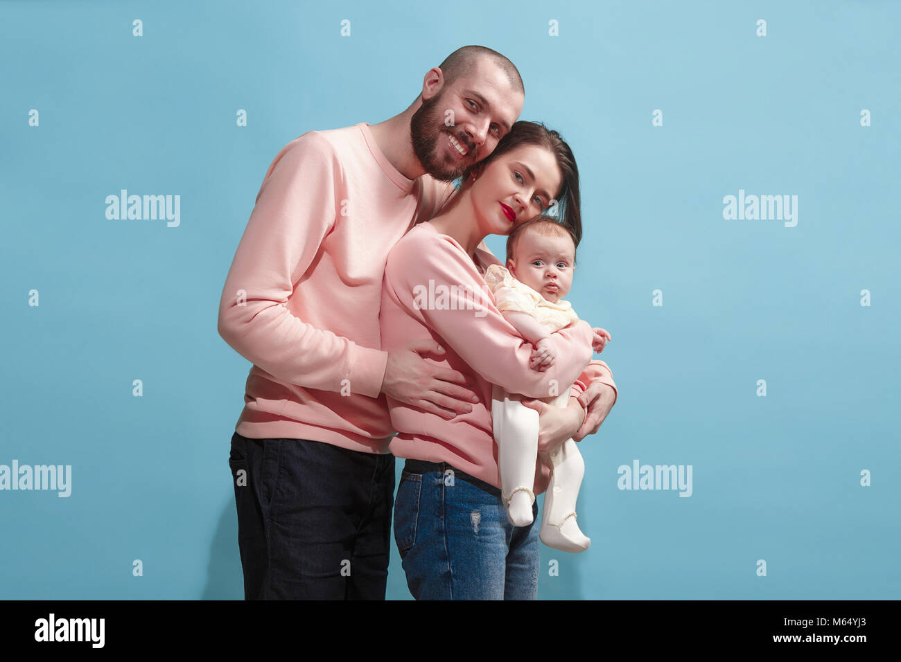 Happy family on the blue studio background Stock Photo - Alamy
