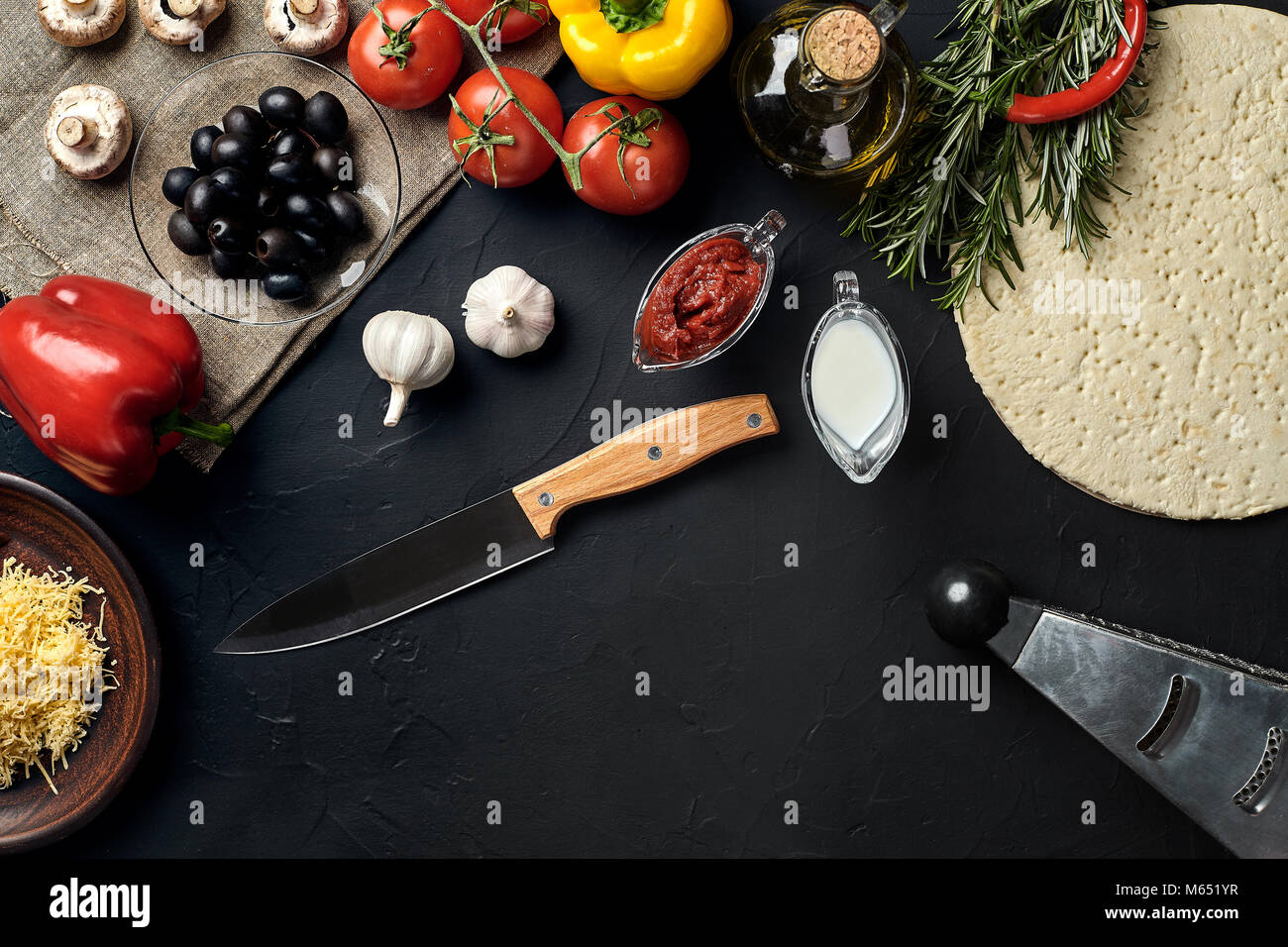 Pizza cooking ingredients. Dough, vegetables and spices. Top view with ...