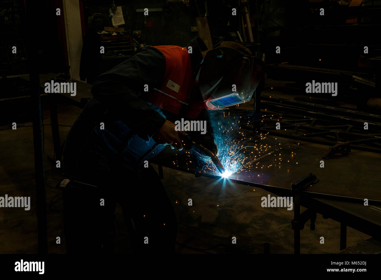 A welders protective visor lit up by the power of the welding gun ...