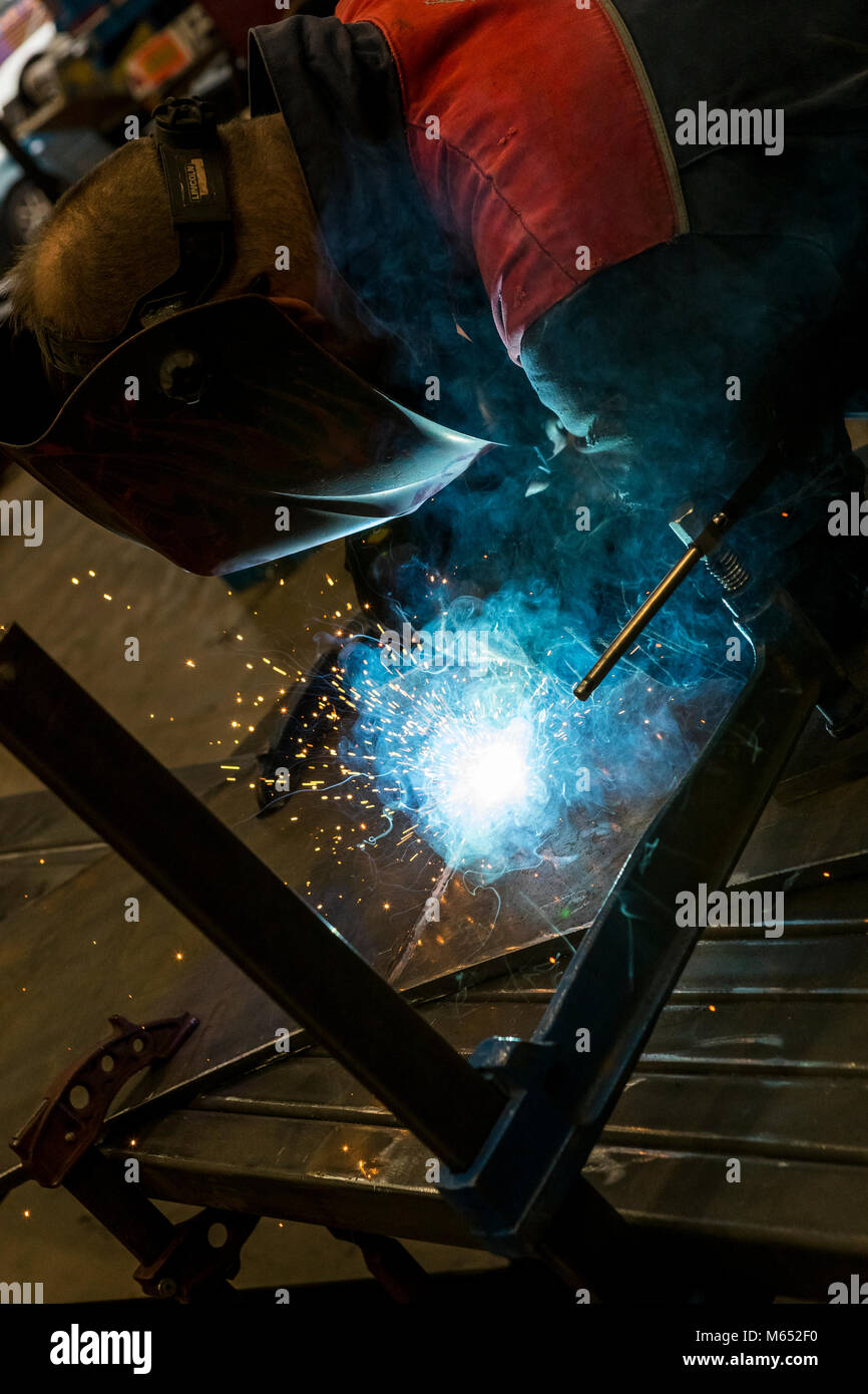 A welders protective visor lit up by the power of the welding gun ...