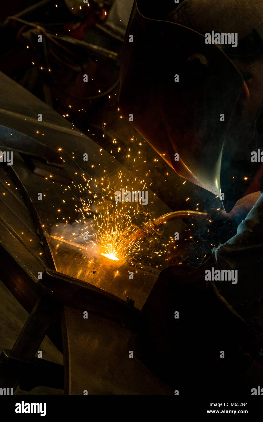 A welders protective visor lit up by the power of the welding gun ...