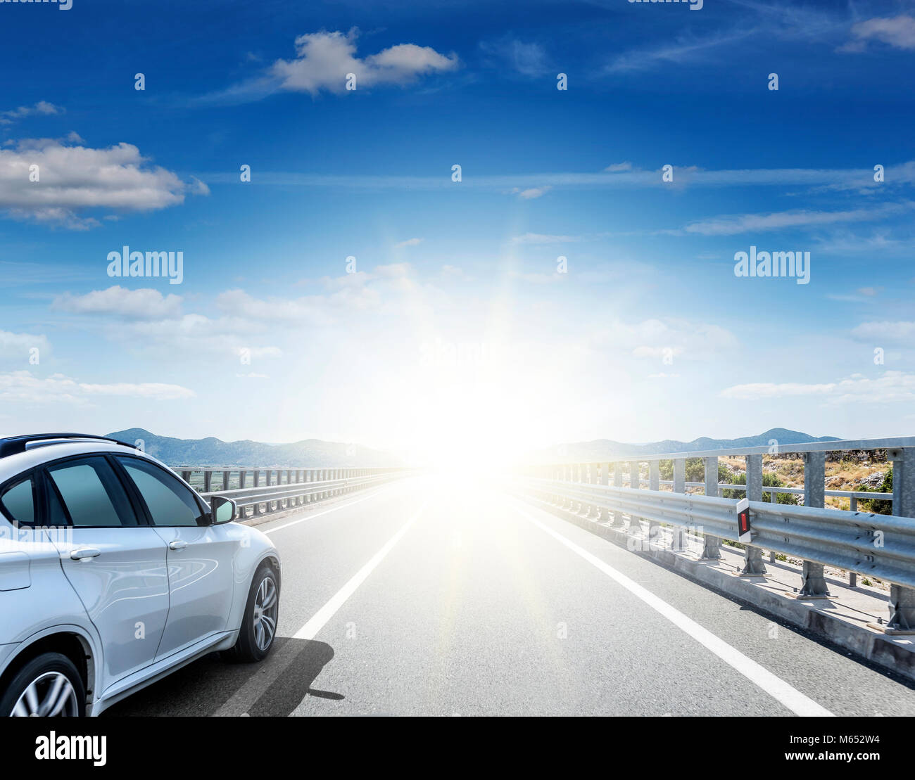 A white car rushing along a high-speed highway in the sun Stock Photo ...