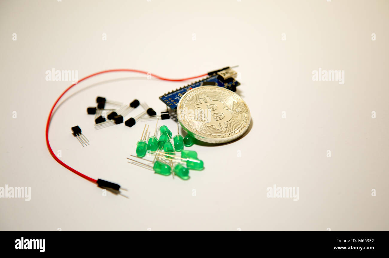 Arduino, bitcoin and around transistors lined up on a white background ...