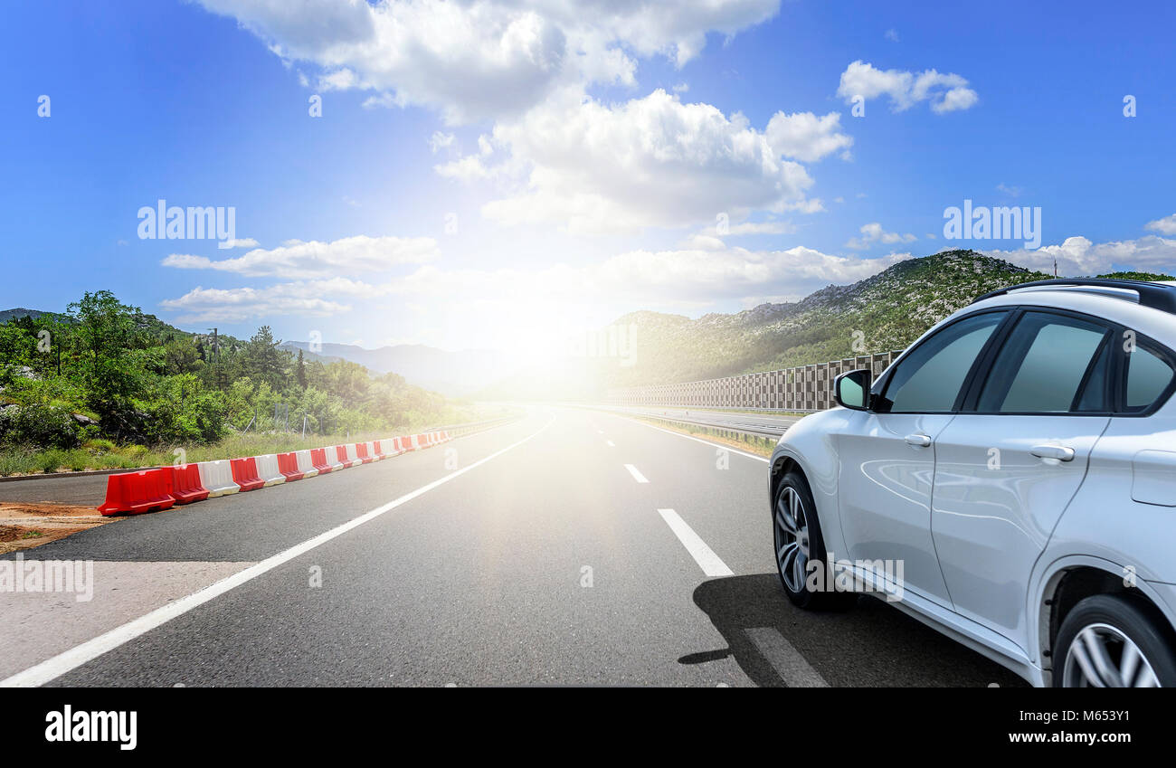 A white car rushing along a high-speed highway in the sun Stock Photo ...