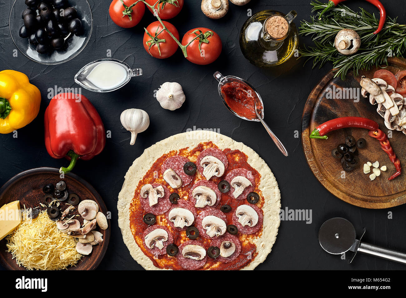 Raw pizza ingredients on black texture table background. Top view. Flat ...