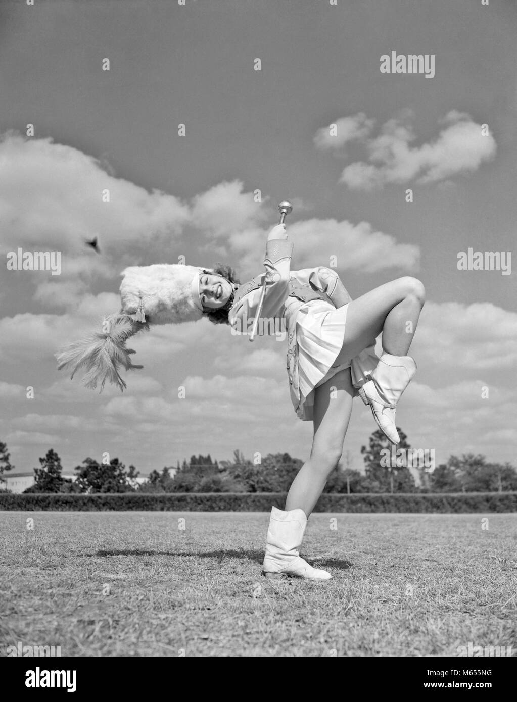 1940s 1950s TEENAGED GIRL MAJORETTE MARCHING ACROSS FIELD WITH BATON ...