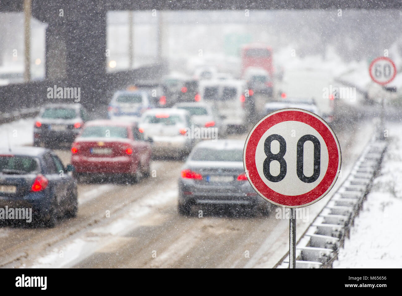 Winter traffic jam during snowstorm with poor visibility. Speed limit ...