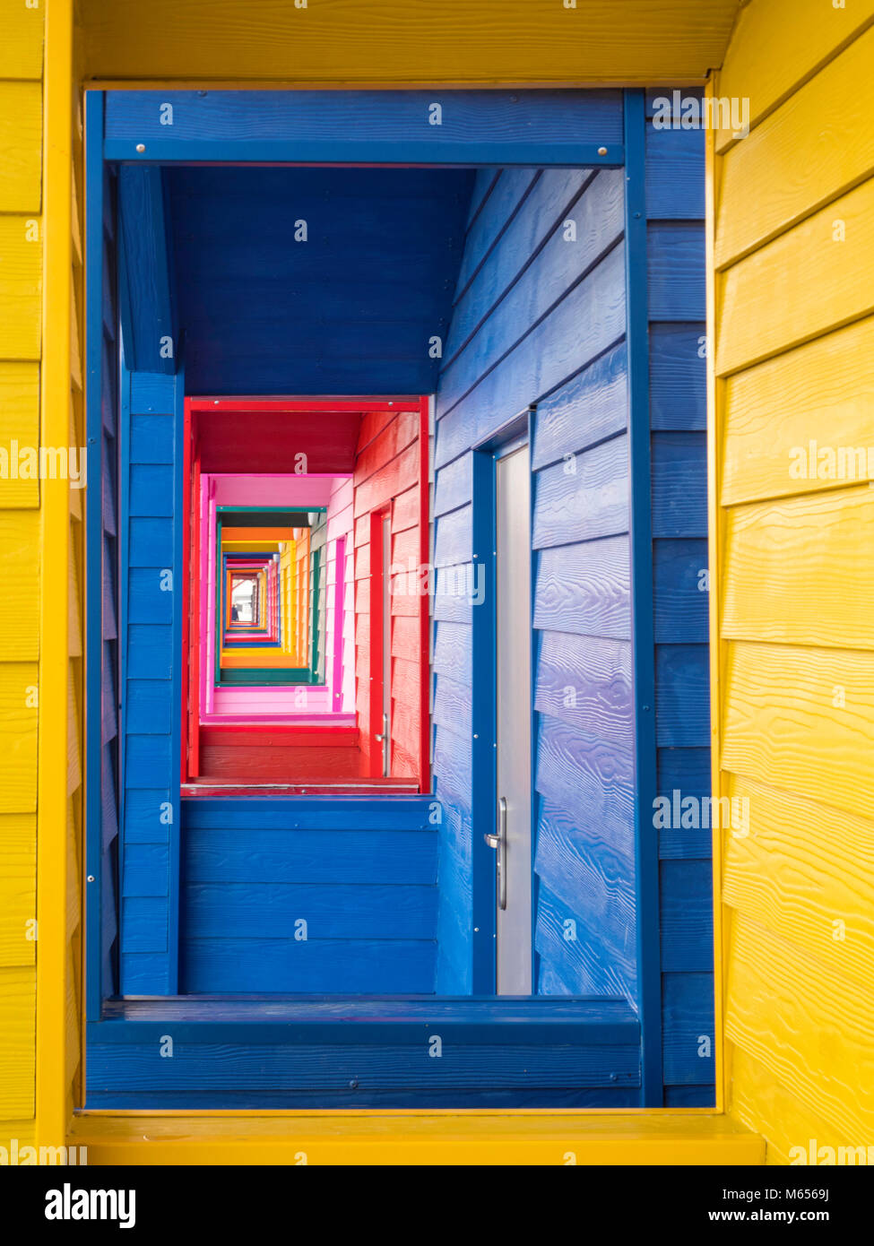 Line of beach huts along Saltburn promenade through the entrance side ...