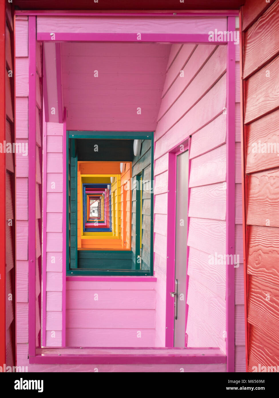 Line of beach huts along Saltburn promenade through the entrance side ...
