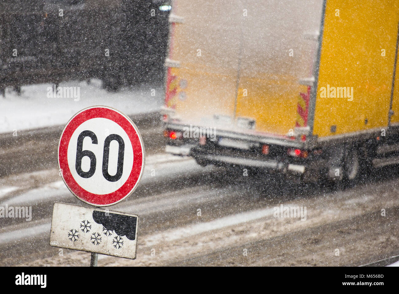 Winter traffic jam during snowstorm with poor visibility. Snow sign and ...