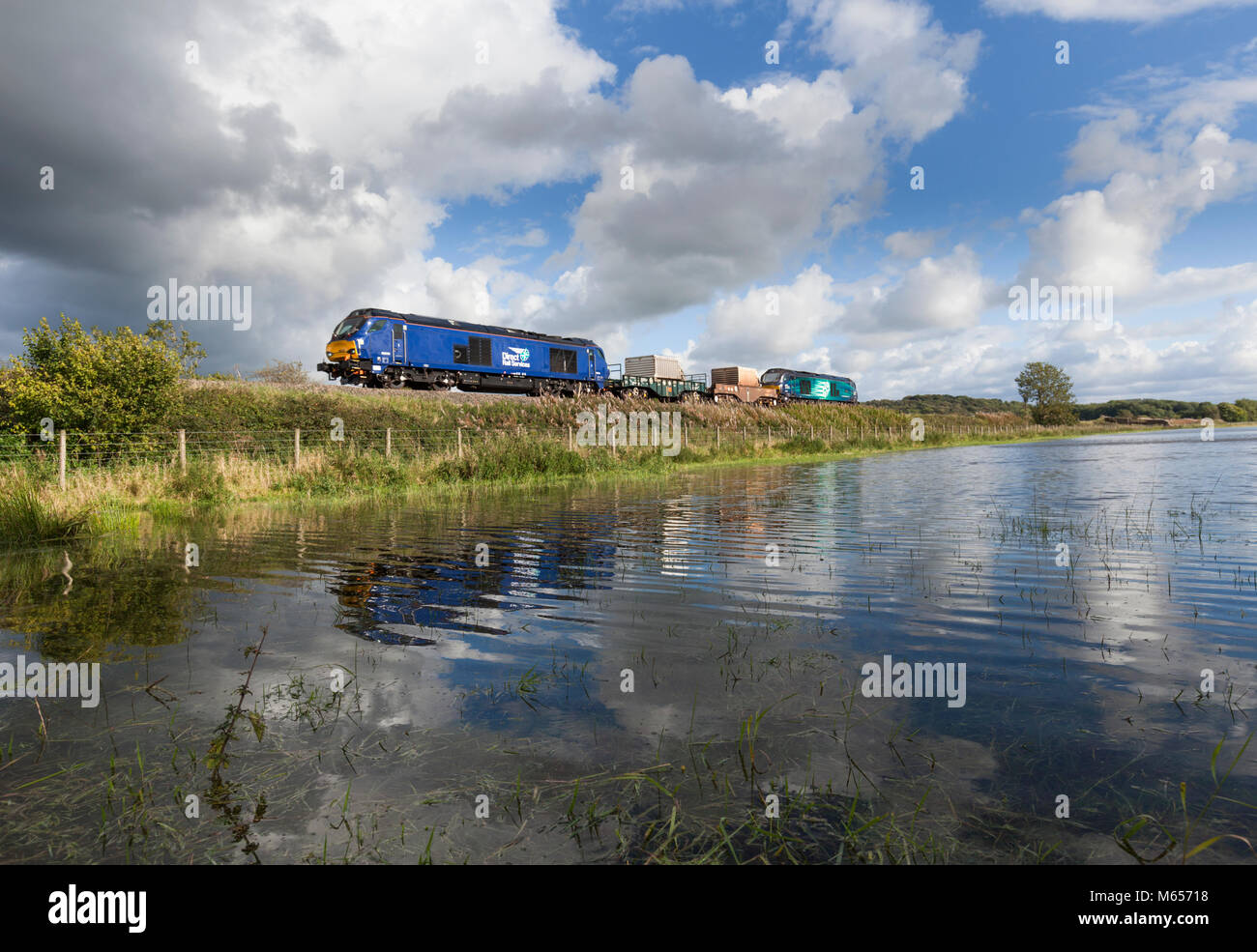 2 Direct rail Services class 68 locomotives reflected in a puddle while ...
