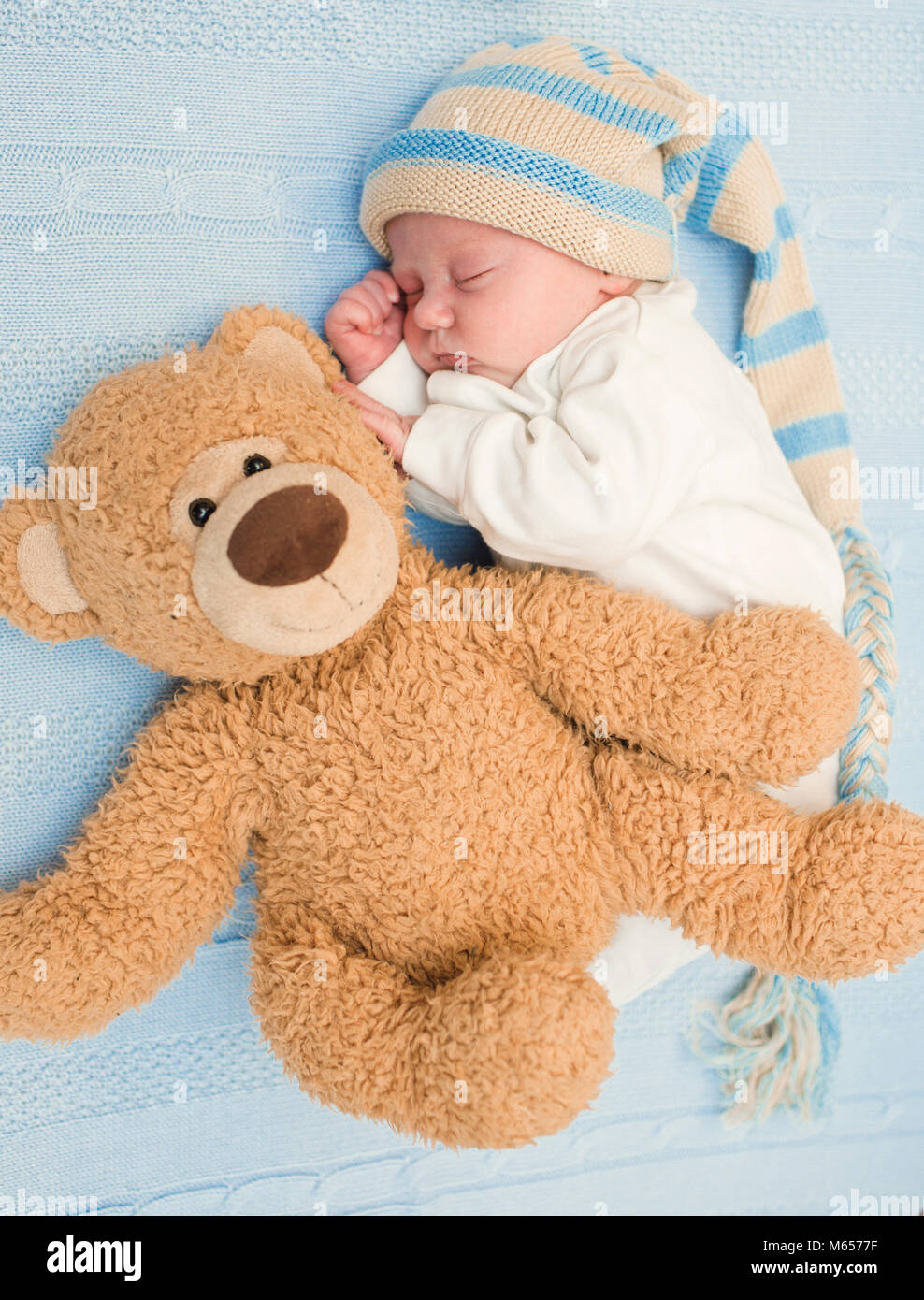 newborn baby laying with teddy bear on blanket Stock Photo - Alamy