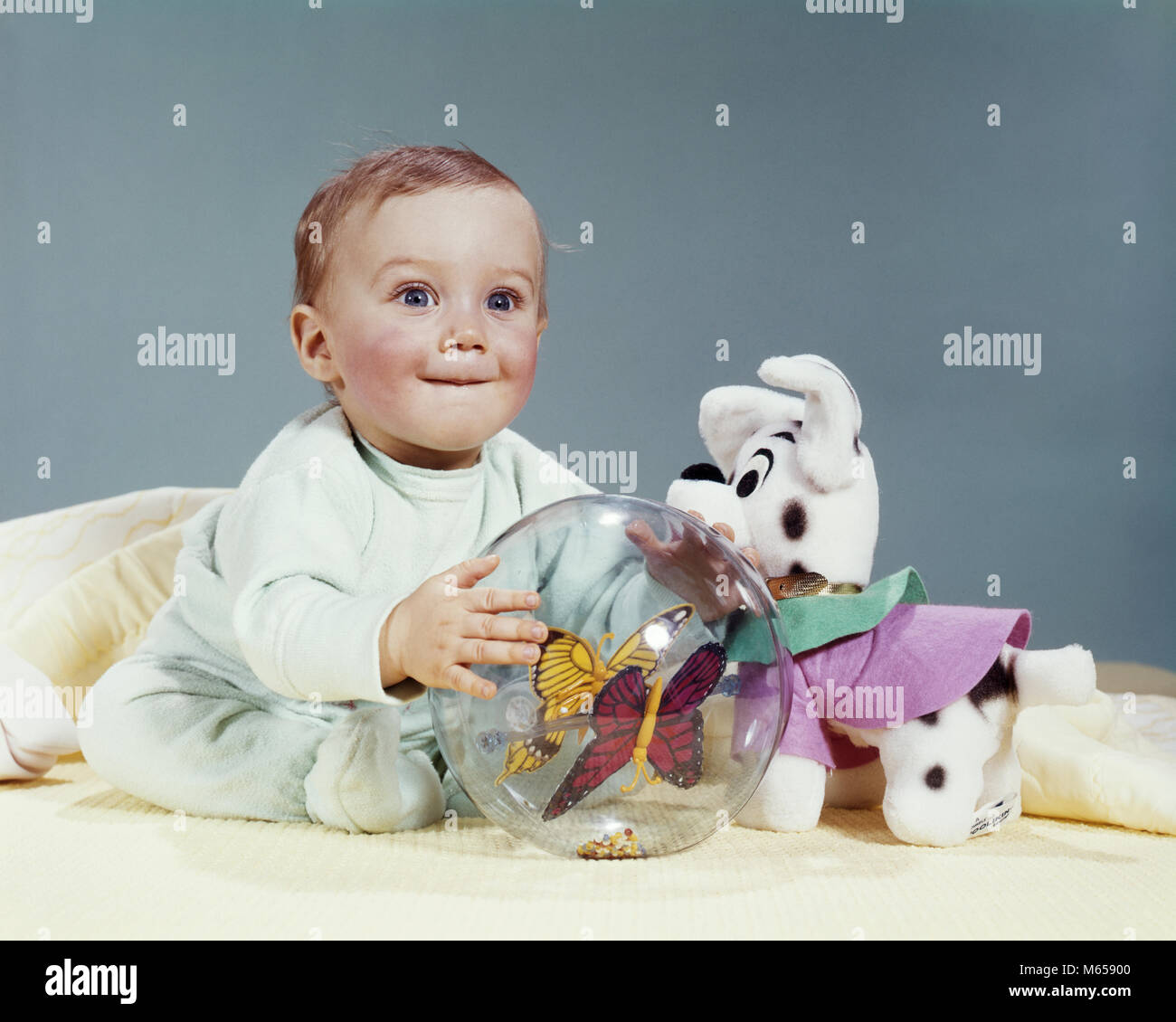 1960s WIDE-EYED BABY CHILD LOOKING AT CAMERA PLAYING WITH TOYS STUFFED ...