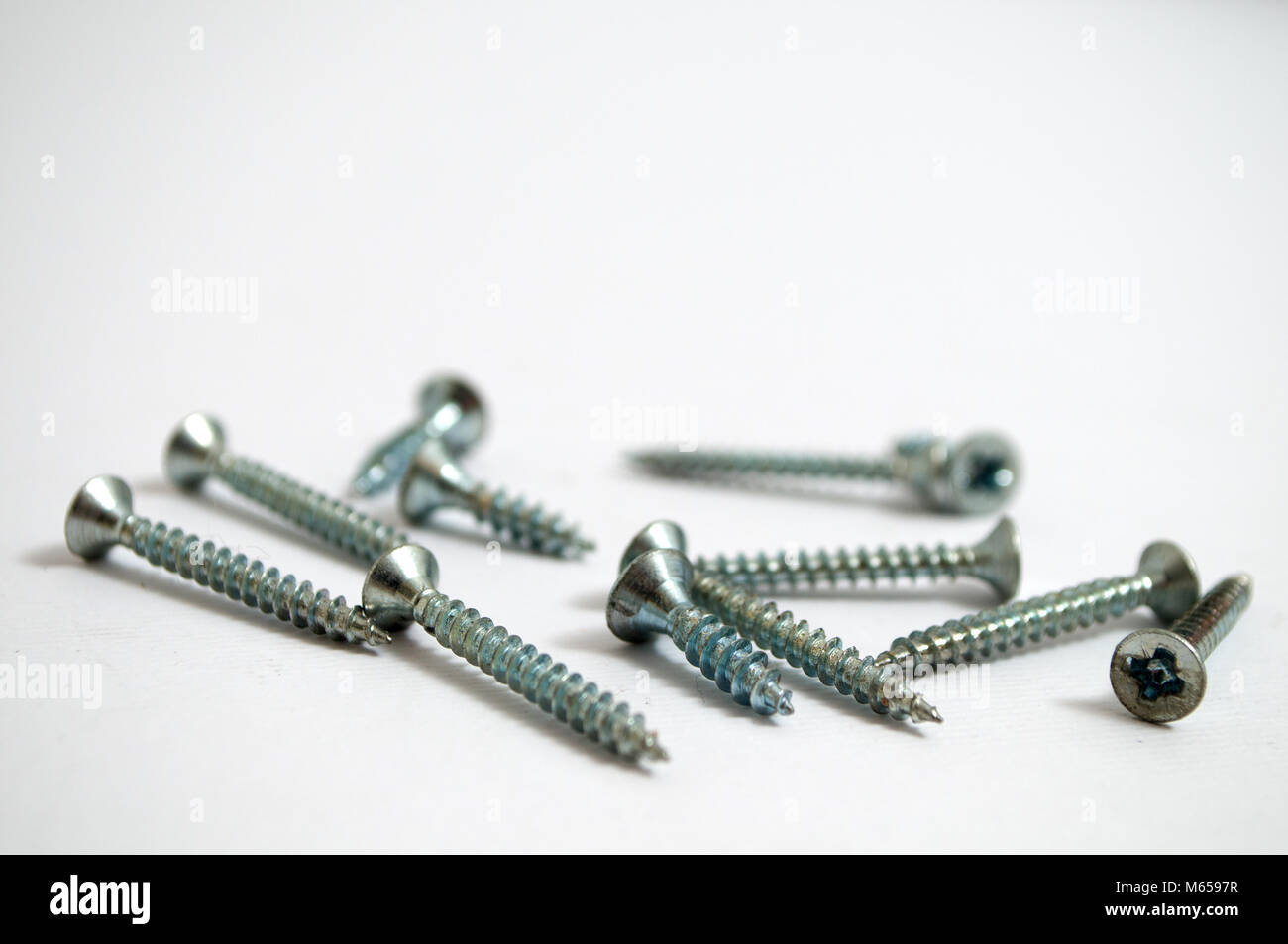 A bunch of screws on a white background Stock Photo - Alamy