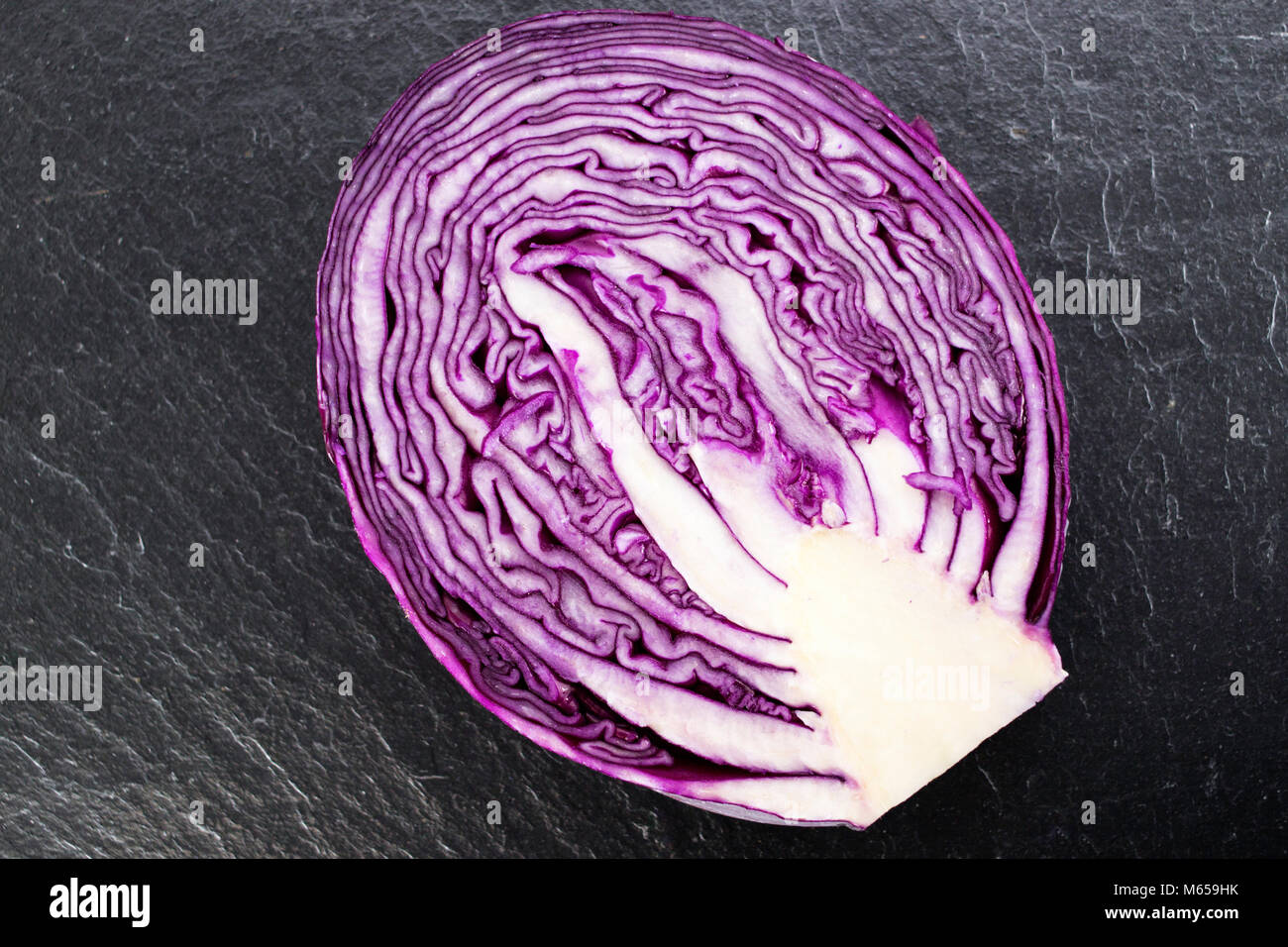 Red cabbage, sliced through, on a grey slate board Stock Photo - Alamy