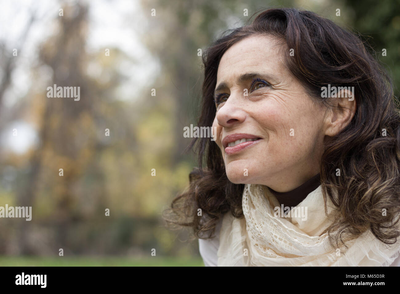 Portrait of mature woman with a vision look in her eyes at park during ...