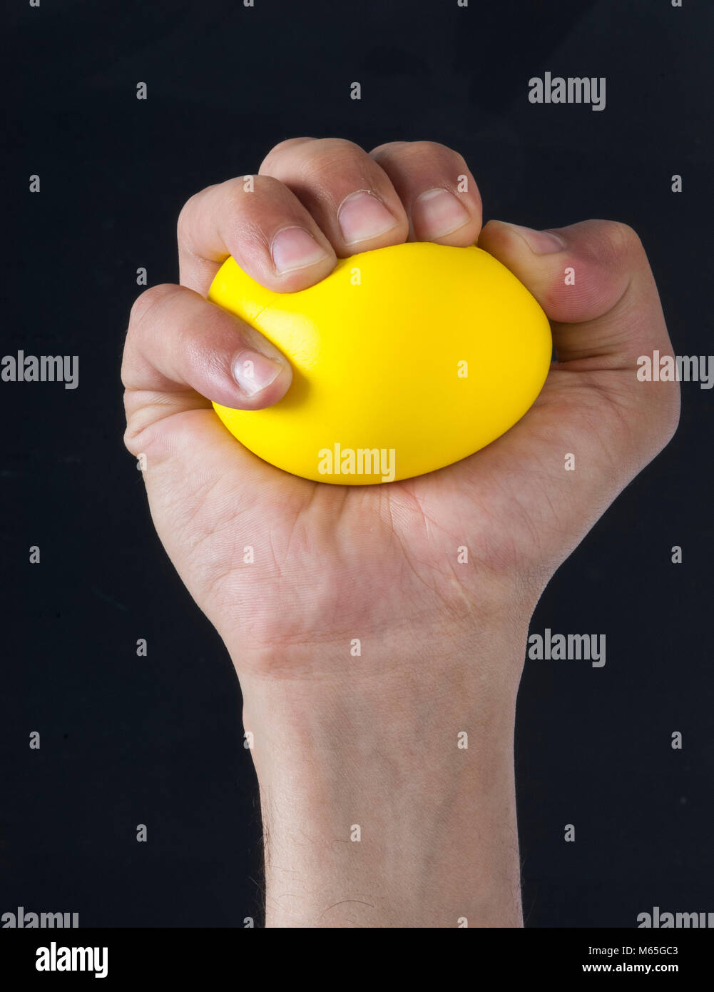 Male Hand Squeezing Yellow Stress Ball Stock Photo - Alamy