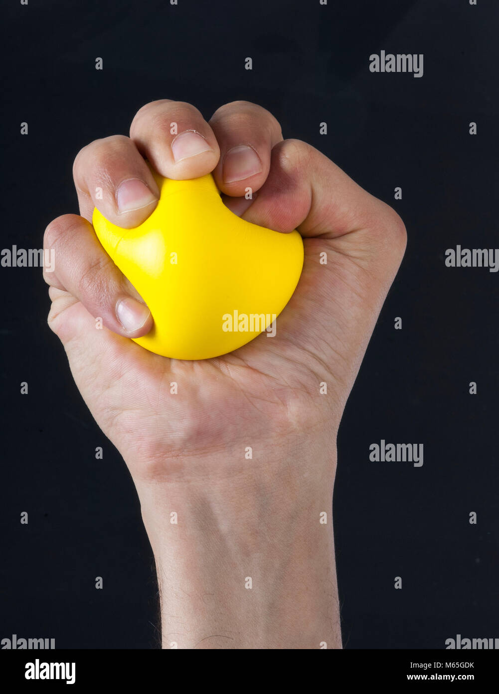 Male Hand Squeezing Yellow Stress Ball Stock Photo - Alamy