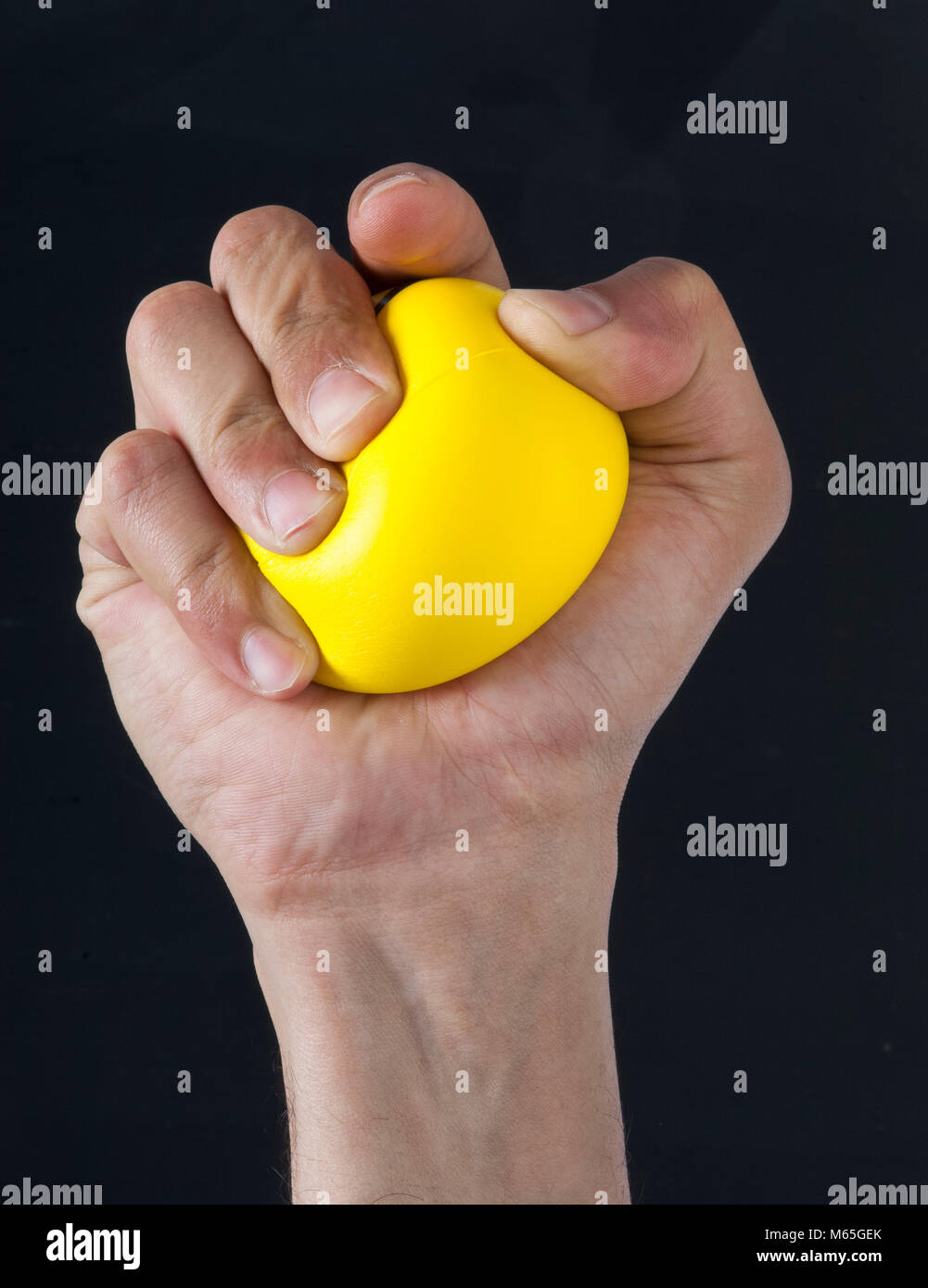 Male Hand Squeezing Yellow Stress Ball Stock Photo - Alamy