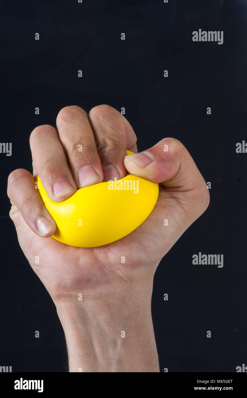Male Hand Squeezing Yellow Stress Ball Stock Photo - Alamy