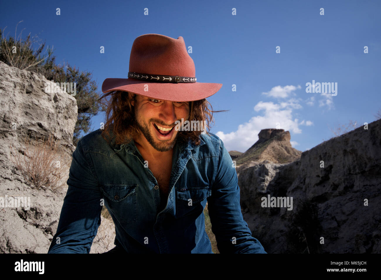 Cowboy looking happy upon finding treasure Stock Photo - Alamy