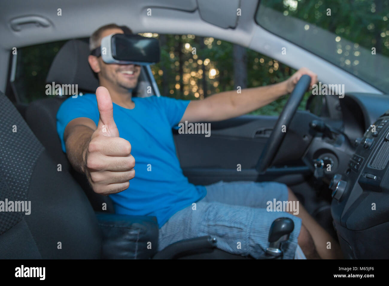 Young man using car driving virtual reality glasses simulation app and ...