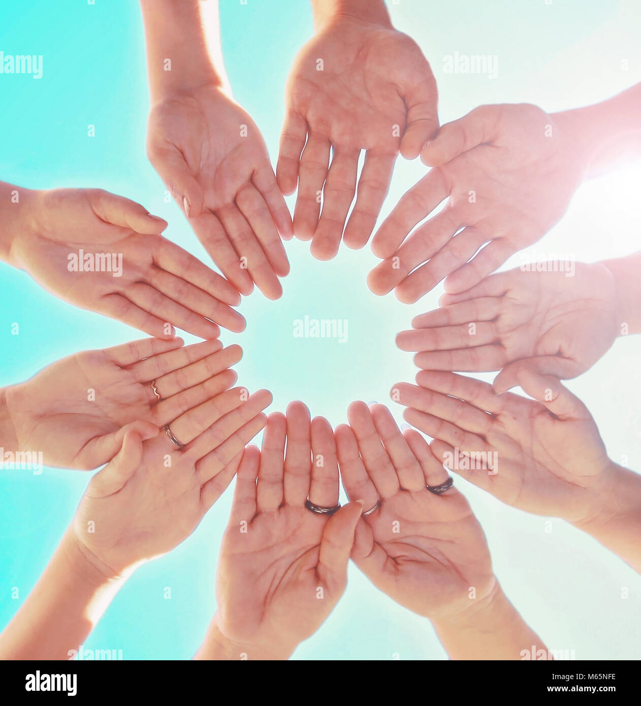 overhead view of a group of people making a circle shape with their ...