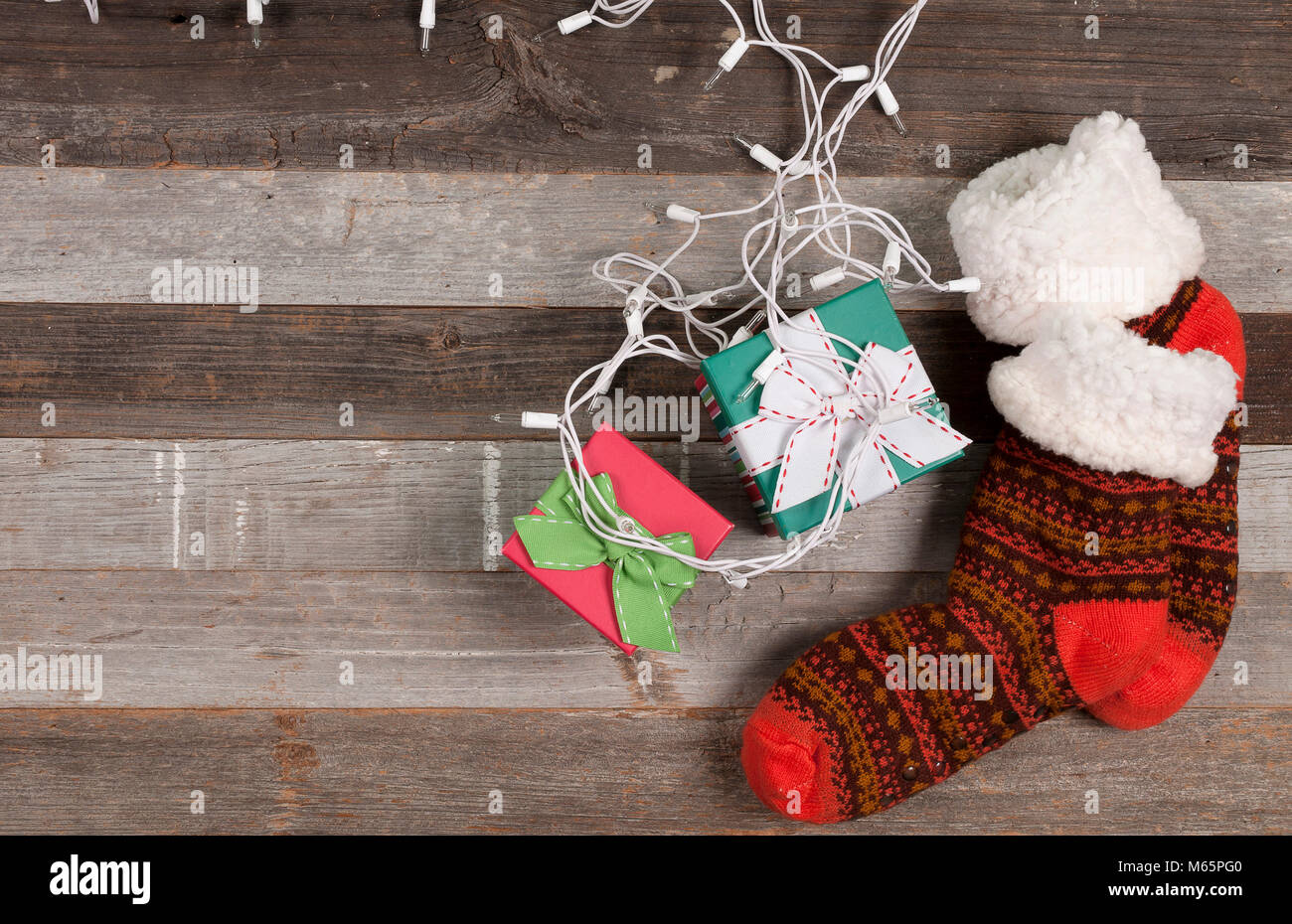 Christmas presents and warm knitted socks on a wooden table. Gifts for ...