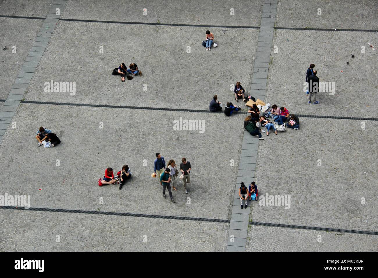 People sitting on the pavement Stock Photo - Alamy