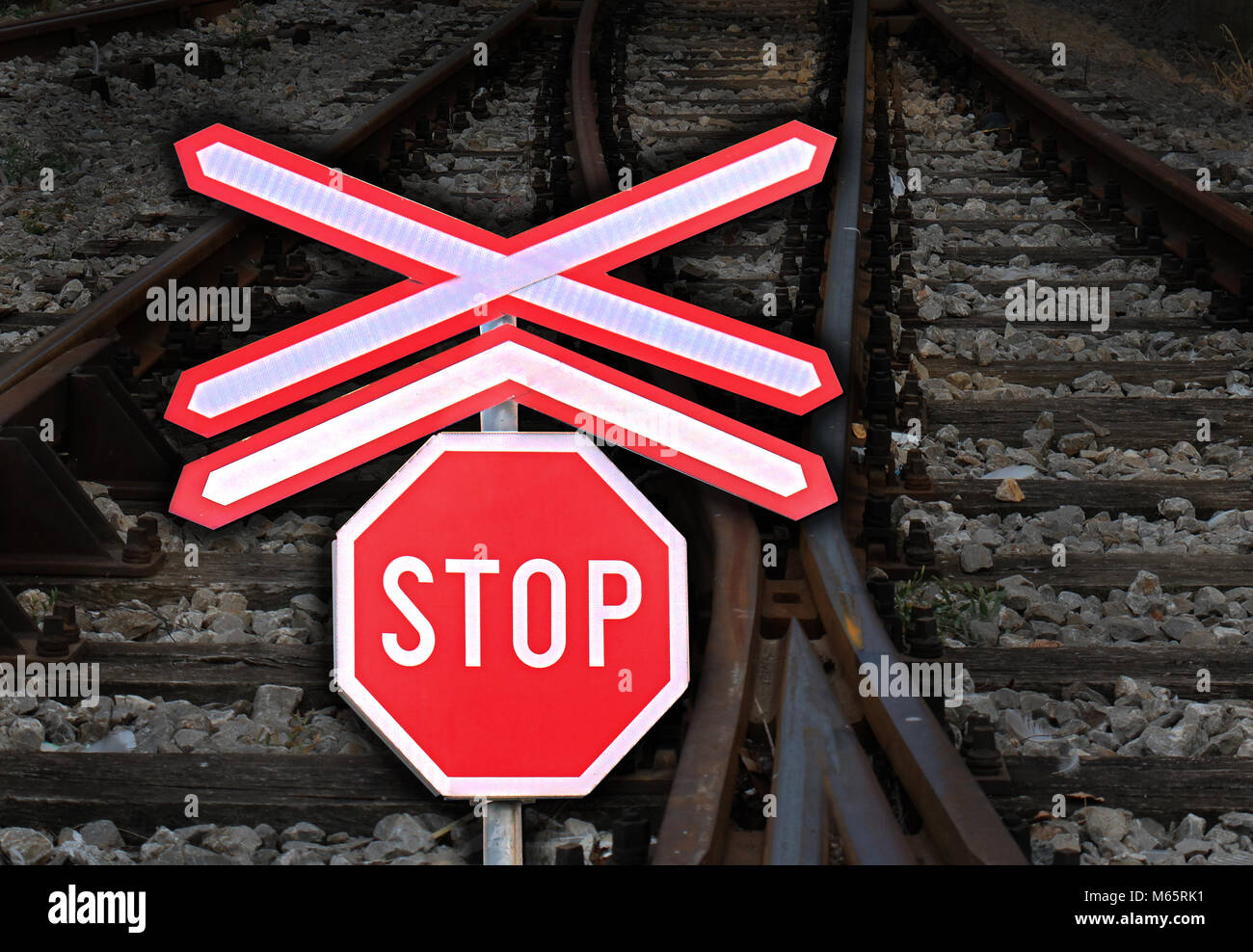 Railway crossing stop sign with empty rail tracks on the background ...