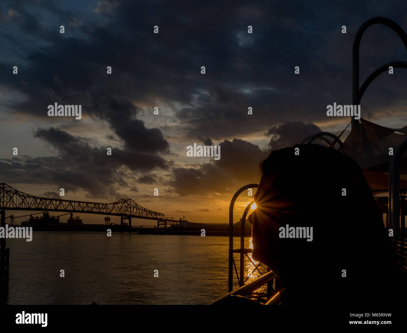 Sunset on river with bridge and ships, sun rays and eyes Stock Photo ...