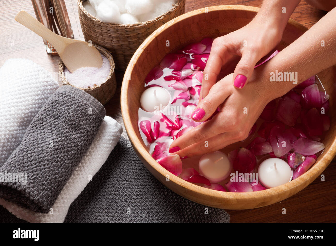 Female hands and bowl of spa water with flowers, hand care in nail ...