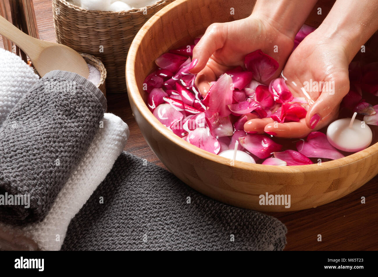 Female hands and bowl of spa water with flowers, hand care in nail ...