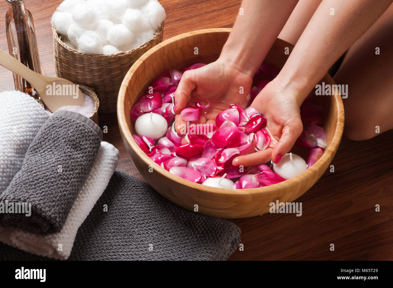 Female hands and bowl of spa water with flowers, hand care in nail ...