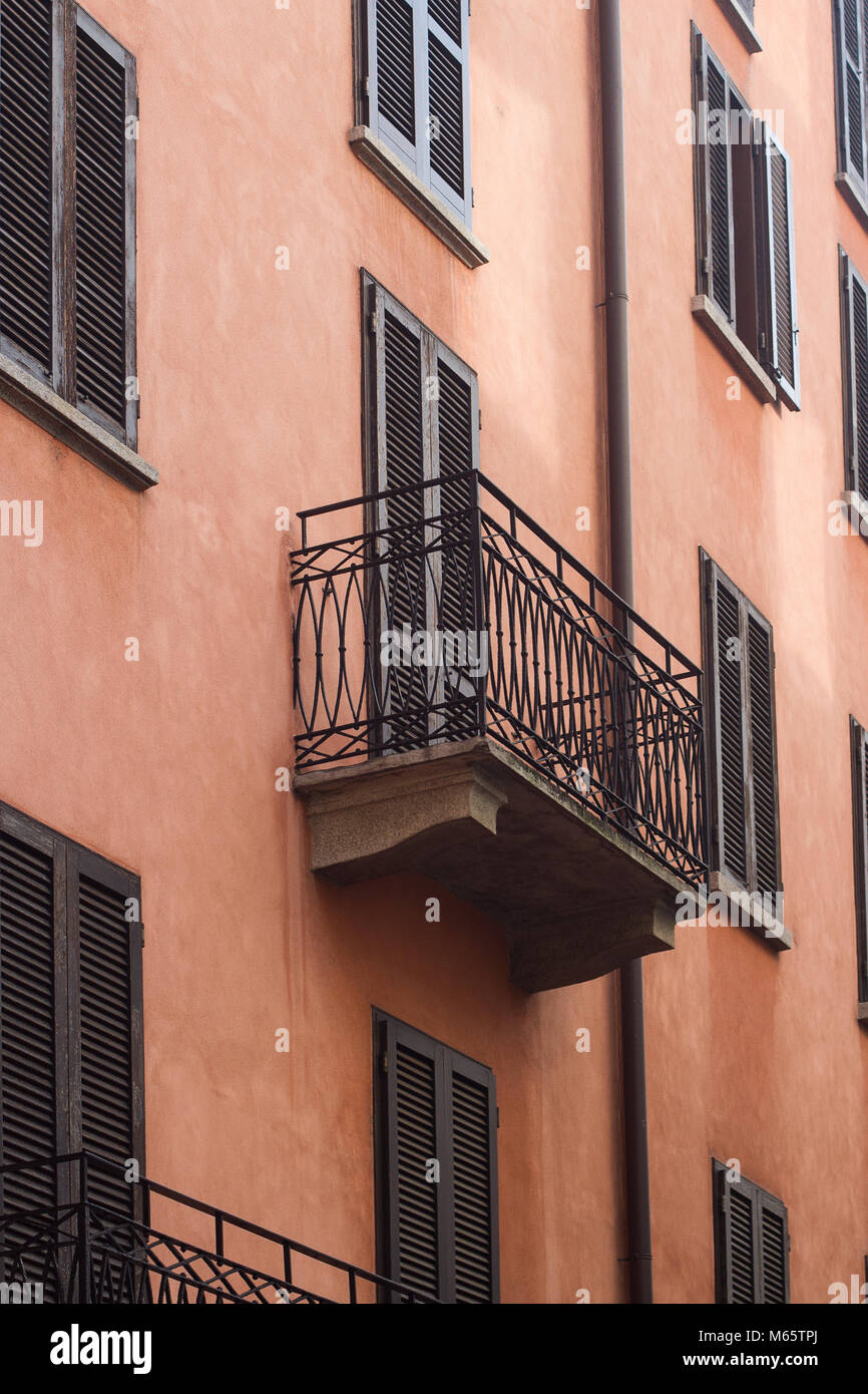 vertical detail perspective view of orange building balcony with tall ...